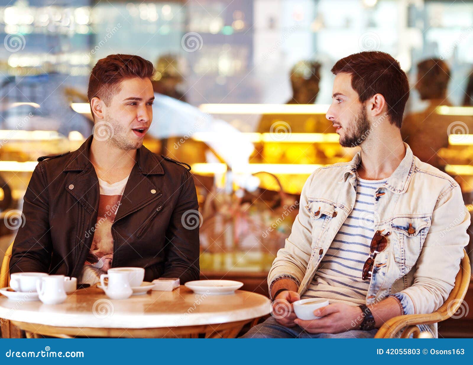 Young Hipster Guy Sitting in a Cafe Chatting and Drinking Coffe Stock ...