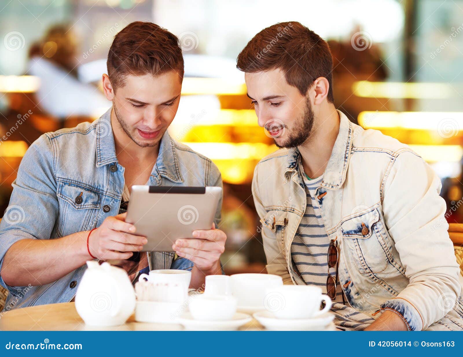 Young Hipster Guy Sitting in a Cafe Chatting and Drinking Coffe Stock ...