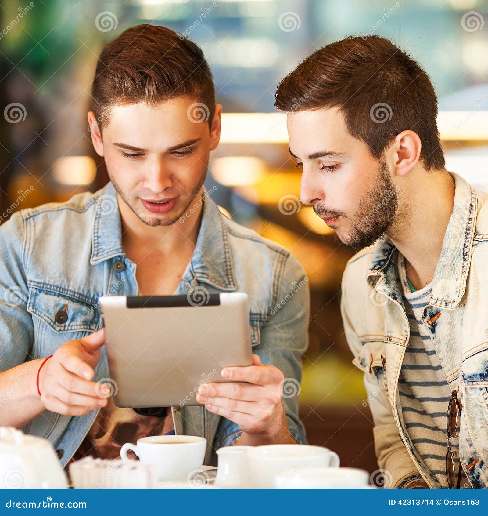 Young Hipster Guy Sitting in a Cafe Chatting and Drinking Coffe Stock ...
