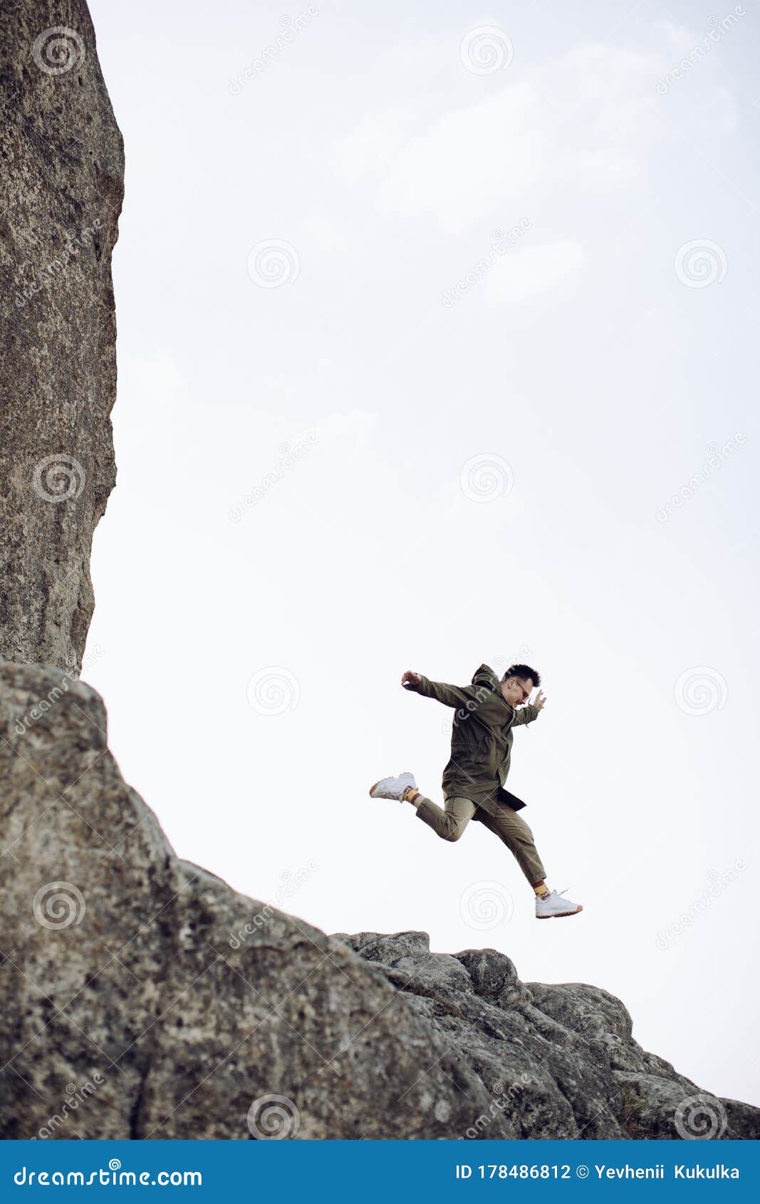 A Young Hipster Man is Jumping Off a Cliff Stock Photo - Image of ...