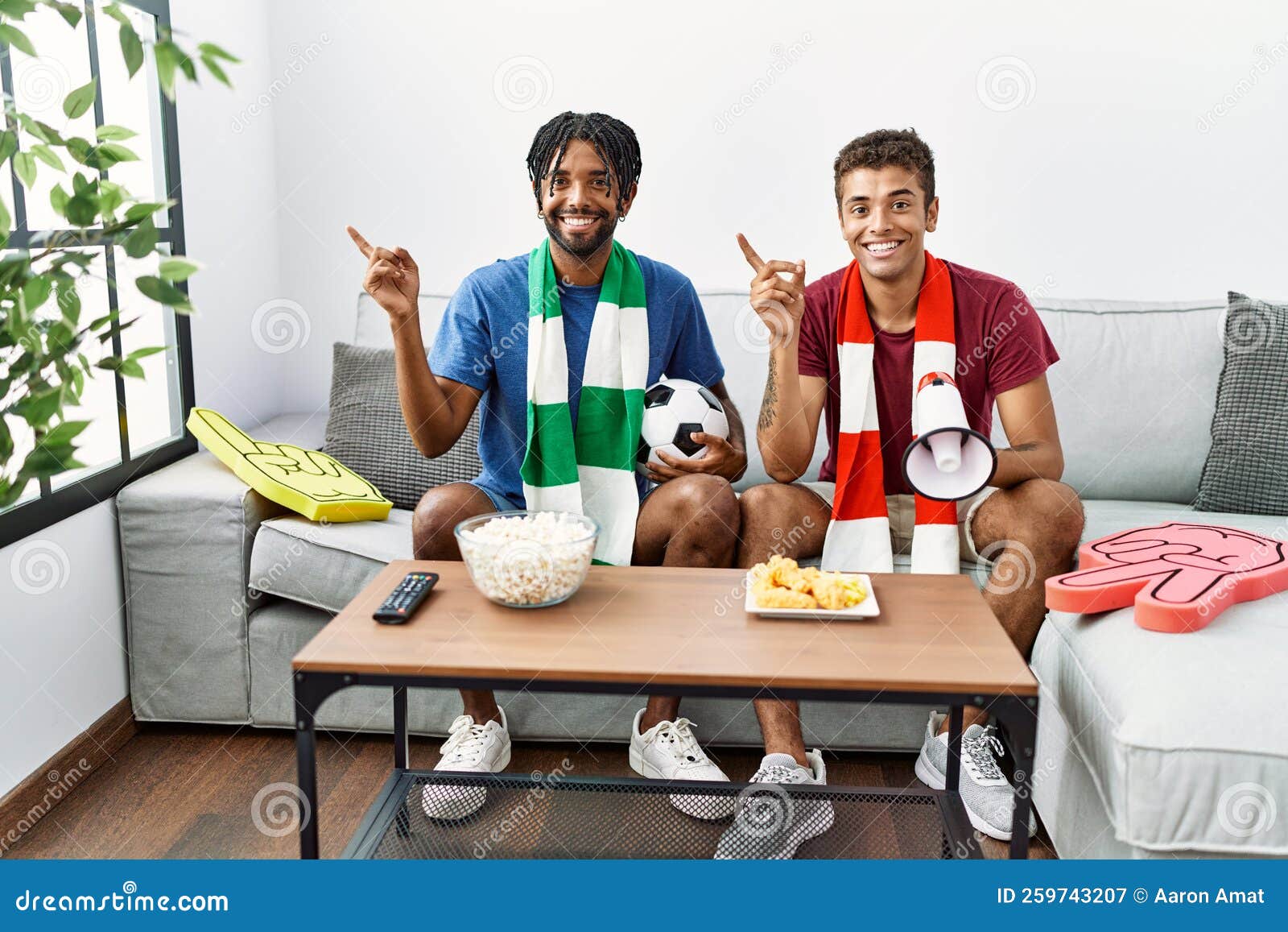 Young Hispanic Brothers Football Hooligans Holding Ball And Megaphone