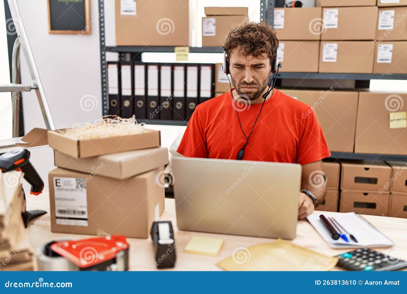 Young Hispanic Call Center Agent Man Working at Warehouse Depressed and ...