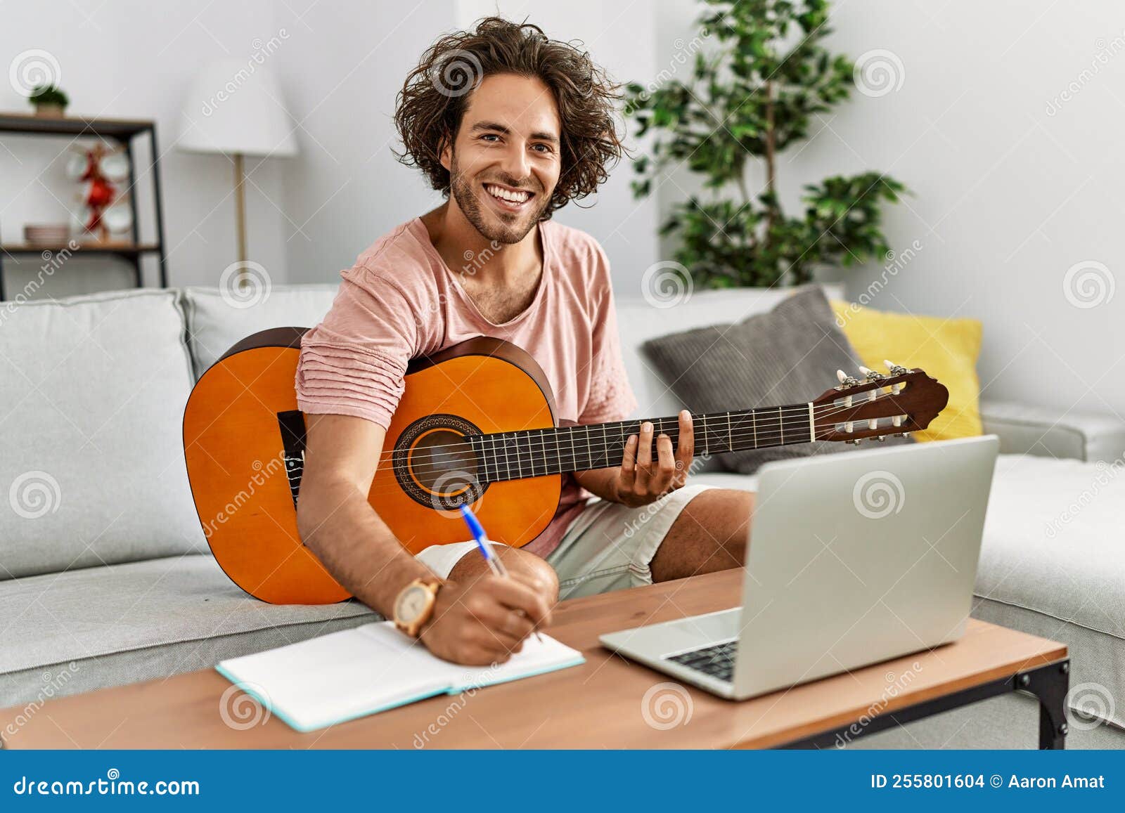 Young Hispanic Composer Man Composing Song Using Guitar and Laptop at ...