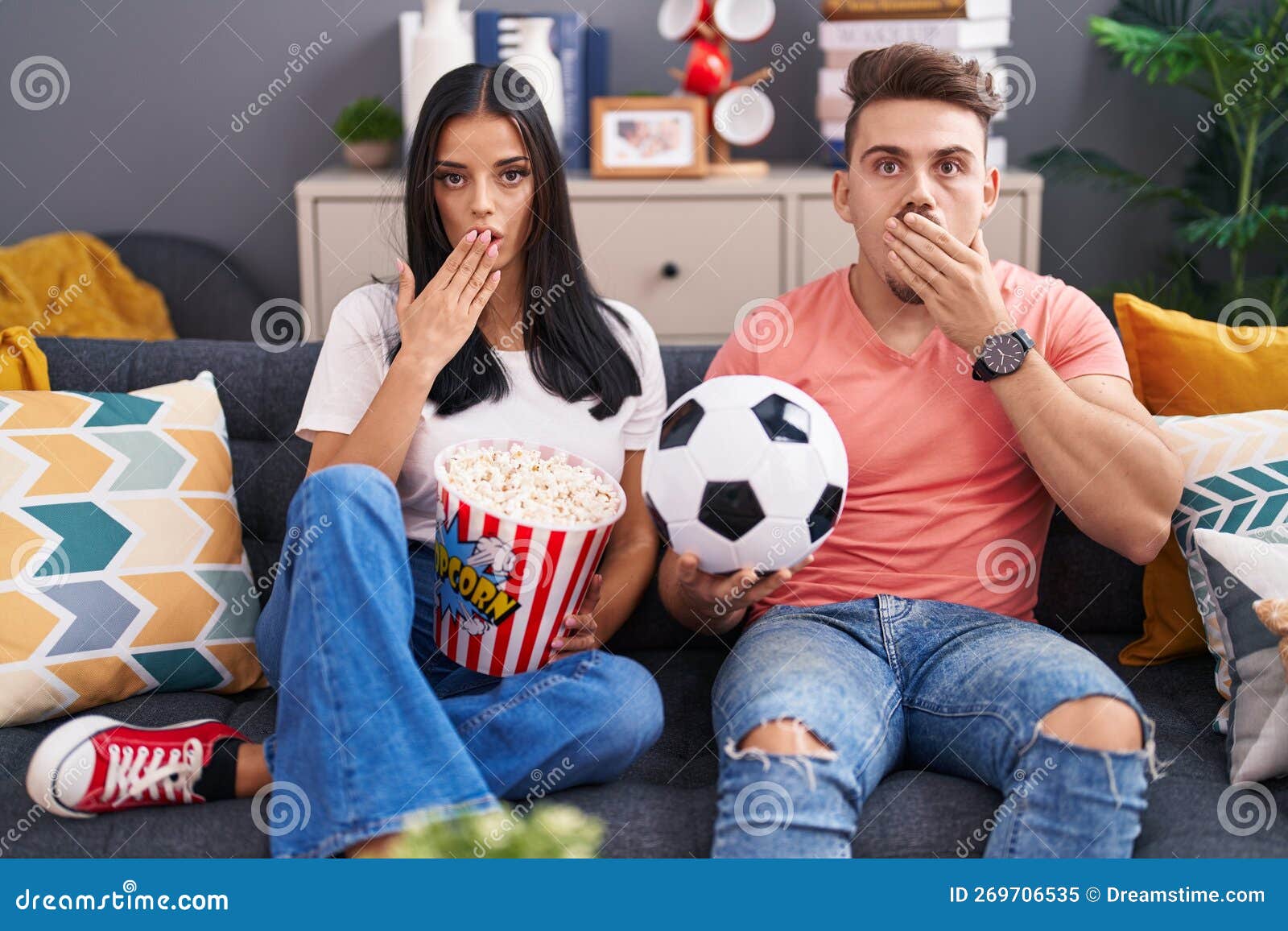 Young Hispanic Couple Football Hooligans Holding Ball And Eating