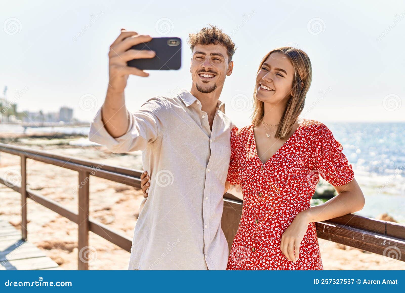Young Hispanic Couple On Vacation Smiling Happy Make Selfie By The