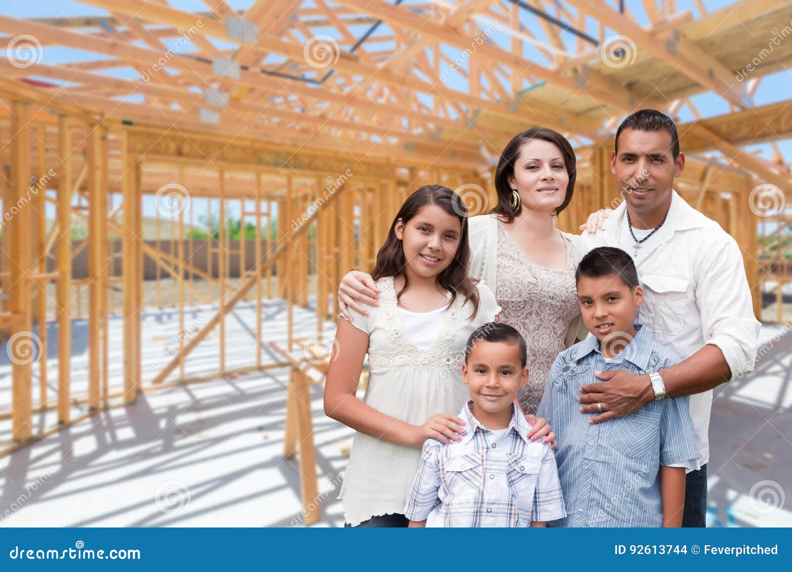 Young Hispanic Family on Site Inside New Home Construction Framing ...