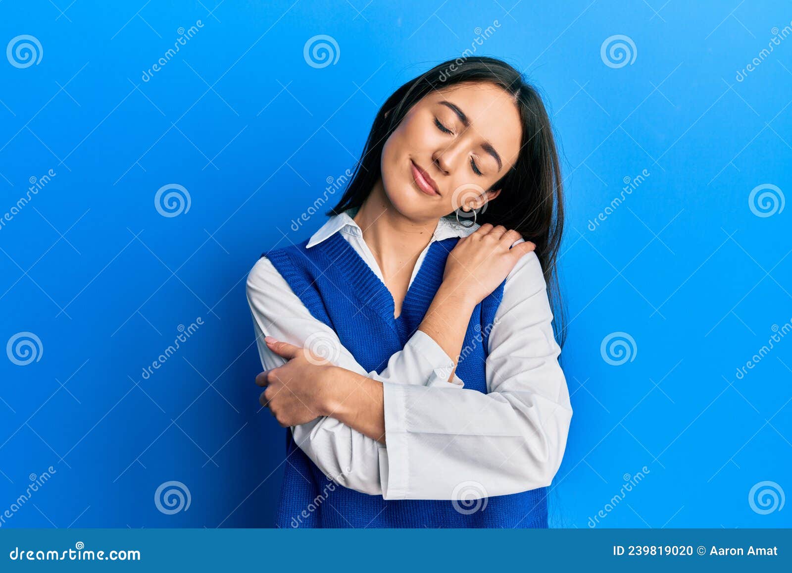 Young Hispanic Girl Wearing Casual Clothes Hugging Oneself Happy And