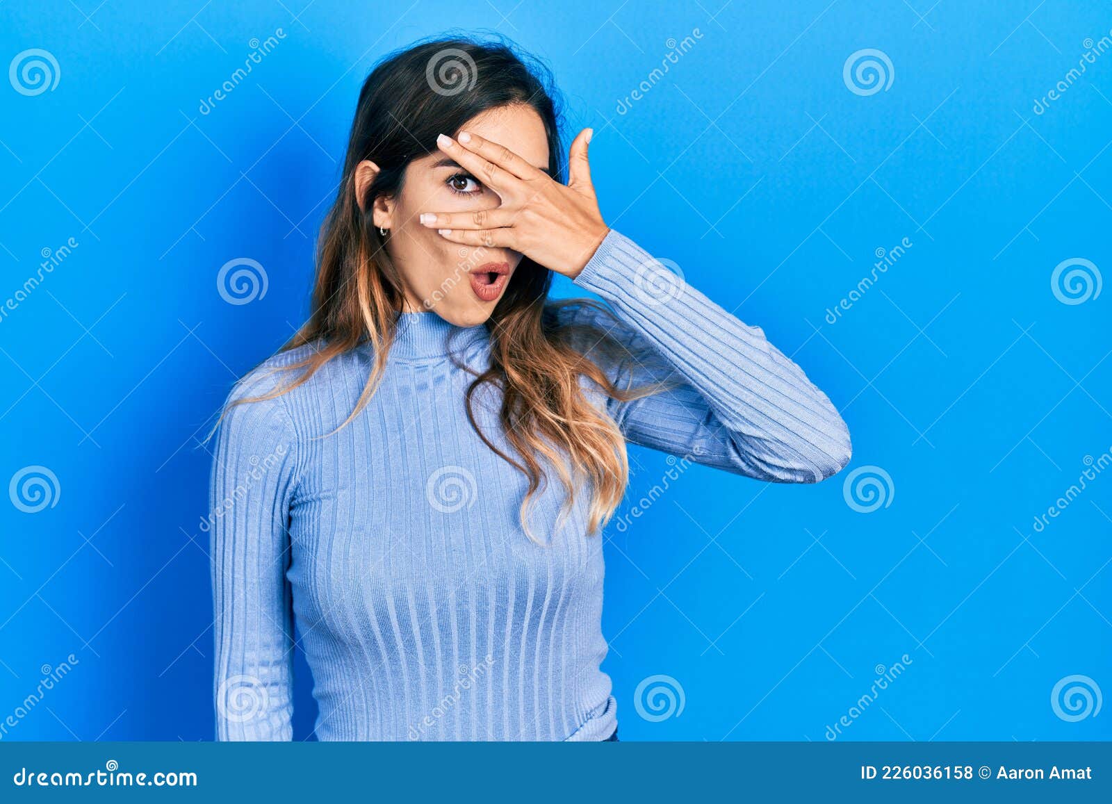 Young Hispanic Girl Wearing Casual Clothes Peeking In Shock Covering