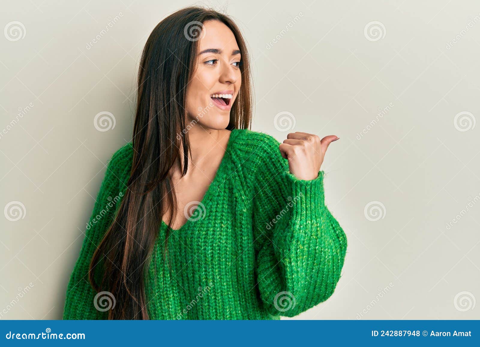 Young Hispanic Girl Wearing Casual Clothes Pointing Thumb Up To The