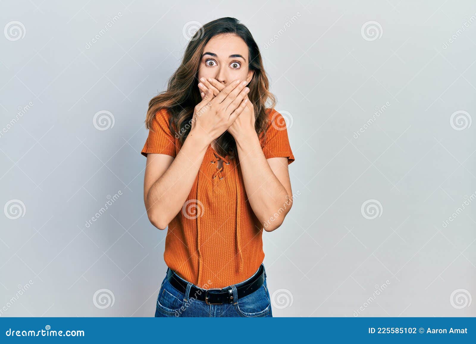 Young Hispanic Girl Wearing Casual Clothes Shocked Covering Mouth With