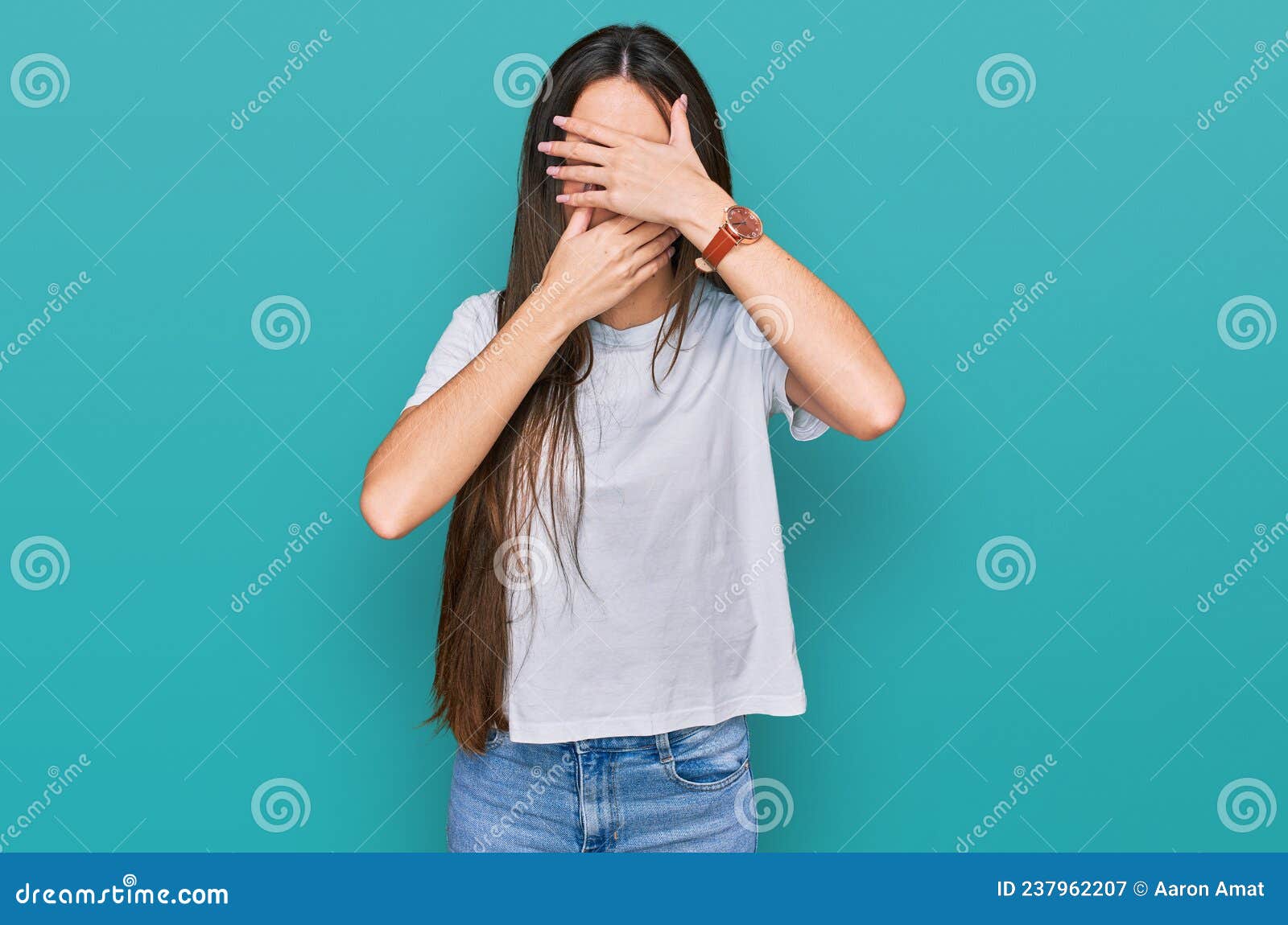 Young Hispanic Girl Wearing Casual White T Shirt Covering Eyes And