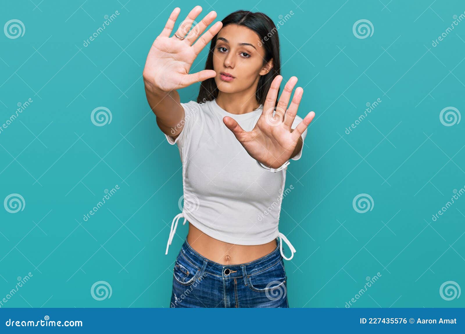 Young Hispanic Girl Wearing Casual White T Shirt Doing Frame Using