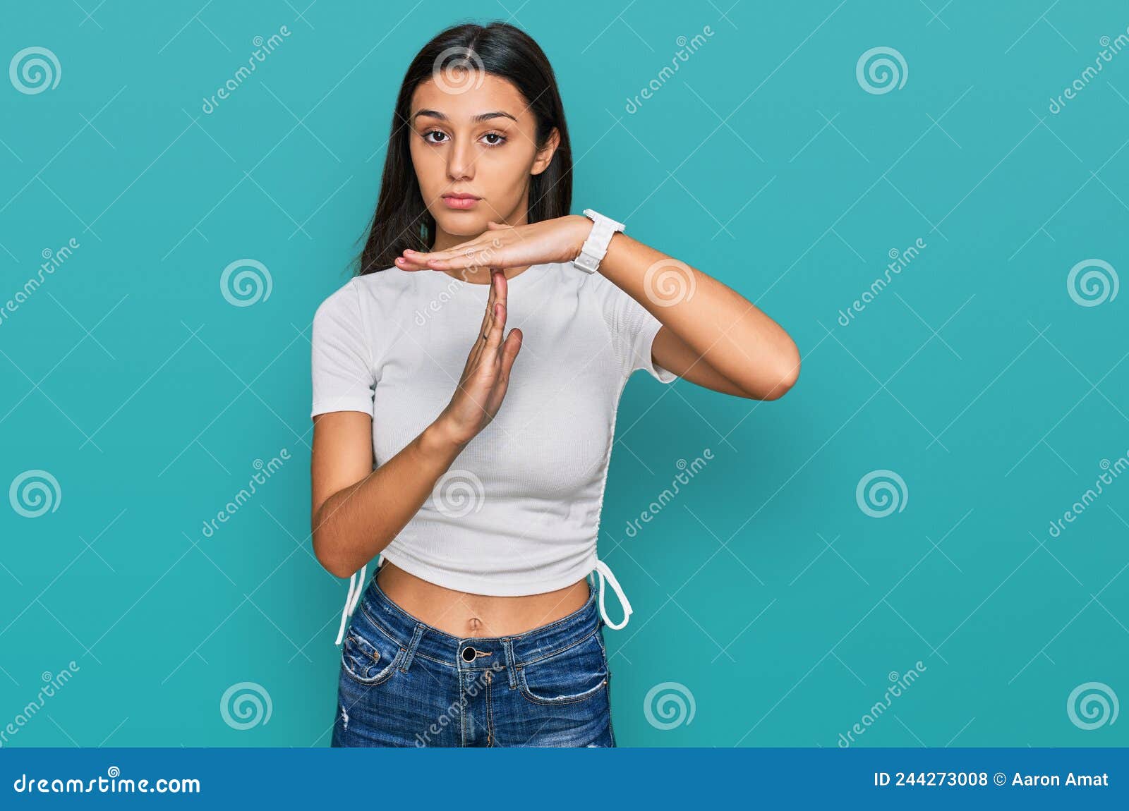 Young Hispanic Girl Wearing Casual White T Shirt Doing Time Out Gesture
