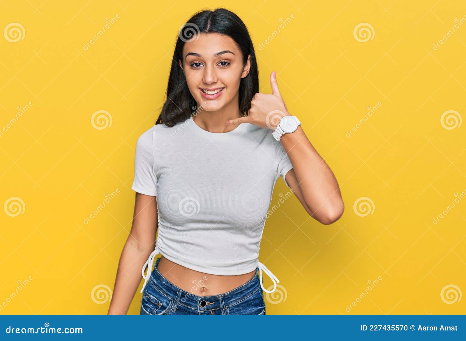 Young Hispanic Girl Wearing Casual White T Shirt Smiling Doing Phone