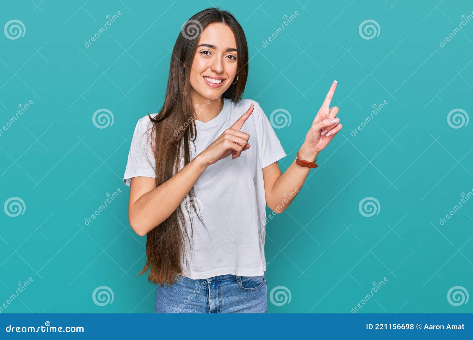 Young Hispanic Girl Wearing Casual White T Shirt Smiling And Looking At