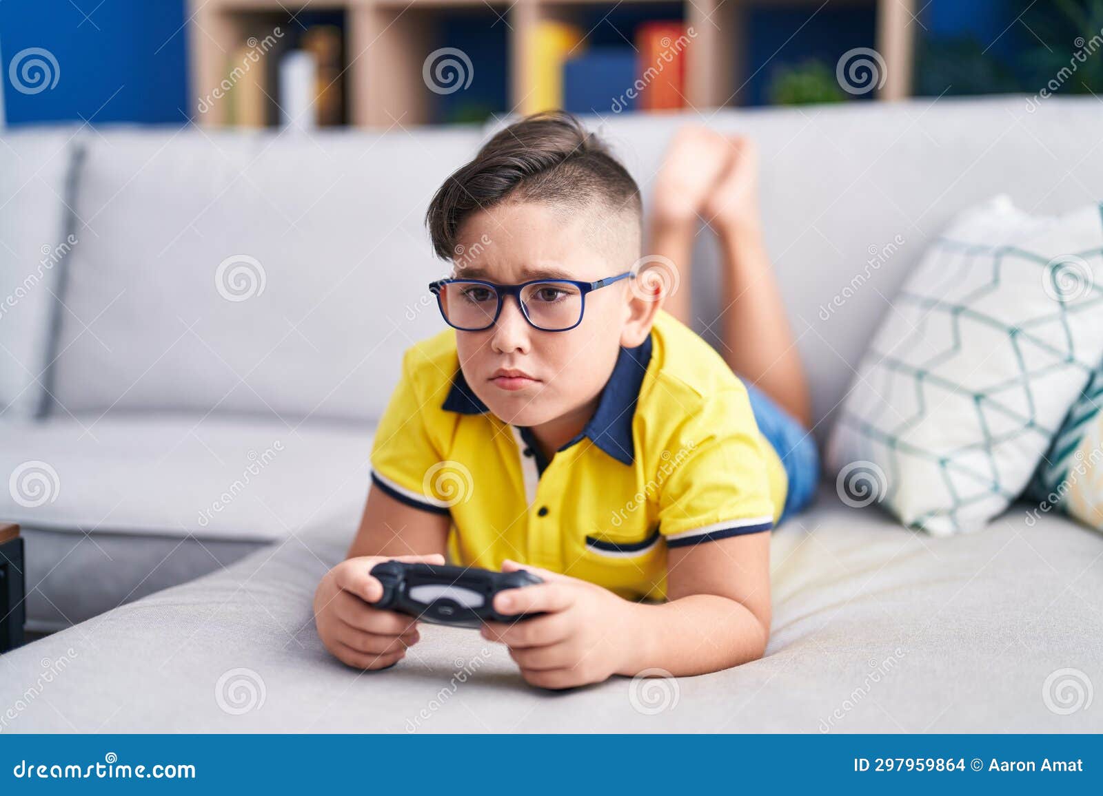 Young Hispanic Kid Playing Video Game Holding Controller on the Sofa ...