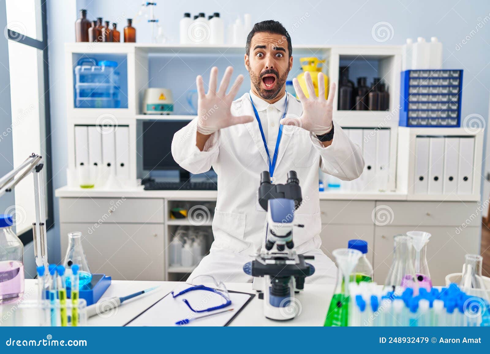 Young Hispanic Man with Beard Working at Scientist Laboratory Afraid ...