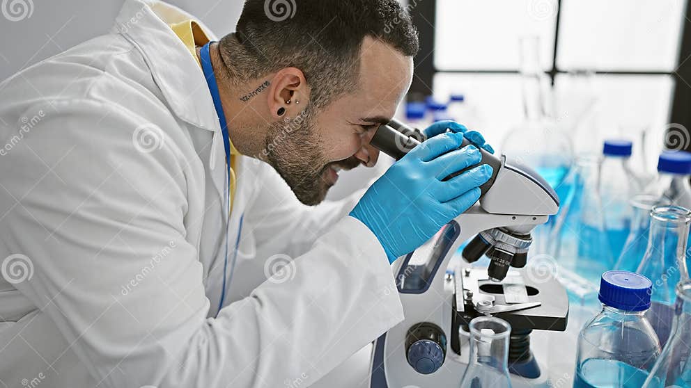 A Young Hispanic Man with a Beard Works Diligently in a Lab, Analyzing ...