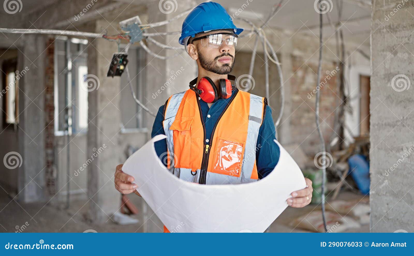 Young Hispanic Man Builder Standing with Blueprints at Construction ...