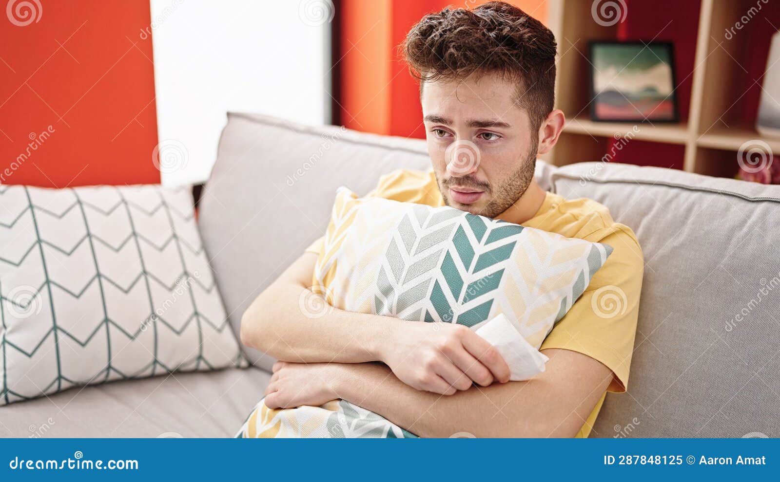Young Hispanic Man Crying Sitting on the Sofa Hugging Pillow at Home ...