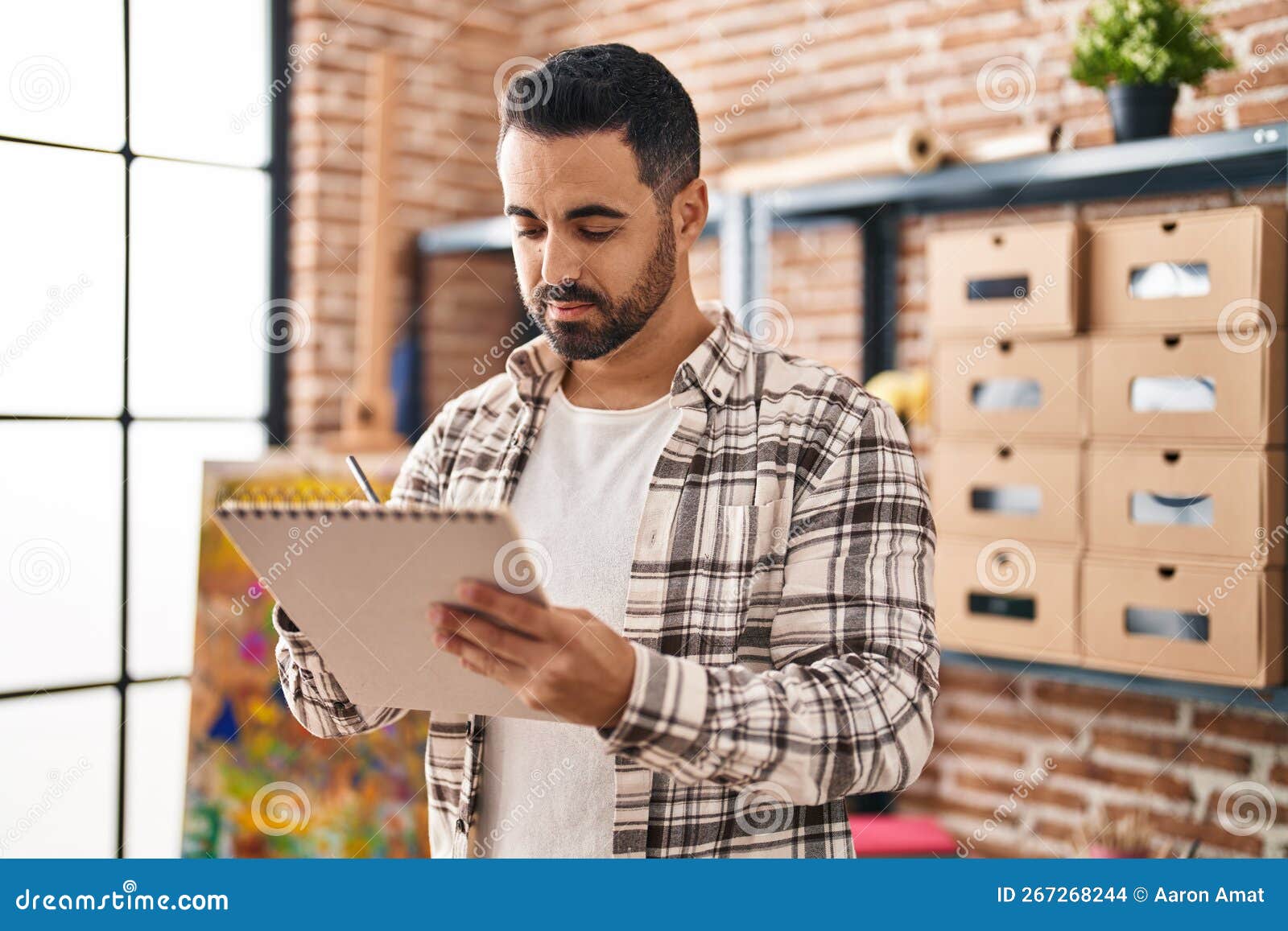 Young Hispanic Man Drawing on Notebook at Art Studio Stock Photo ...