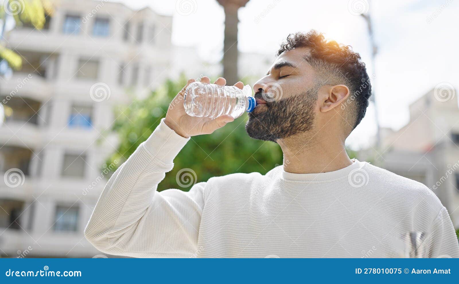 Young Hispanic Man Drinking Water at Park Stock Image - Image of ...