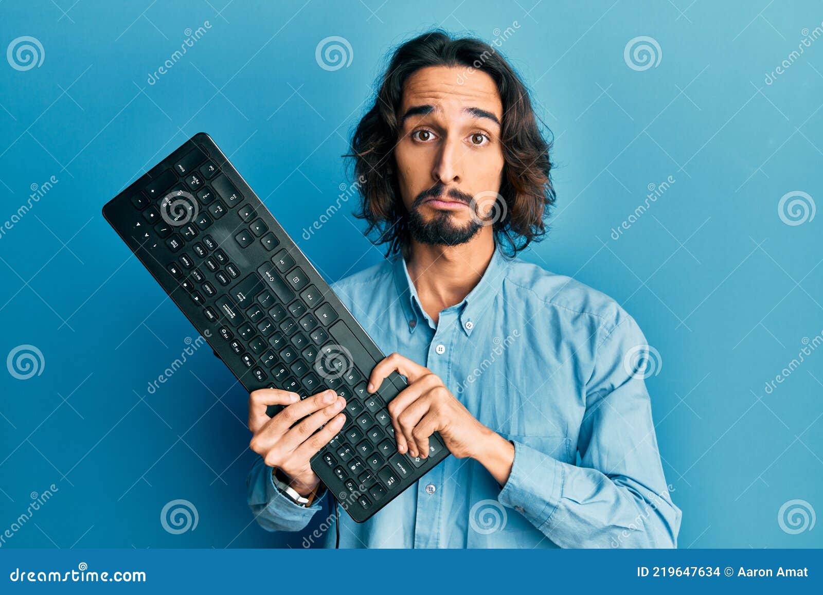 Young Hispanic Man Holding Keyboard Depressed and Worry for Distress ...