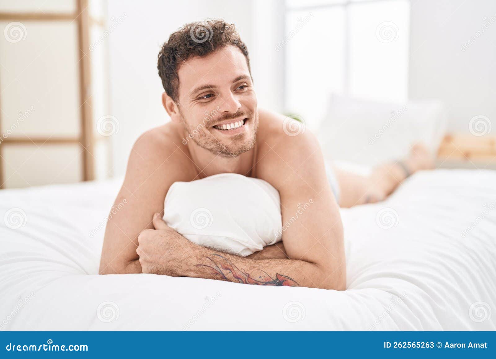 Young Hispanic Man Hugging Pillow Lying on Bed at Bedroom Stock Image ...