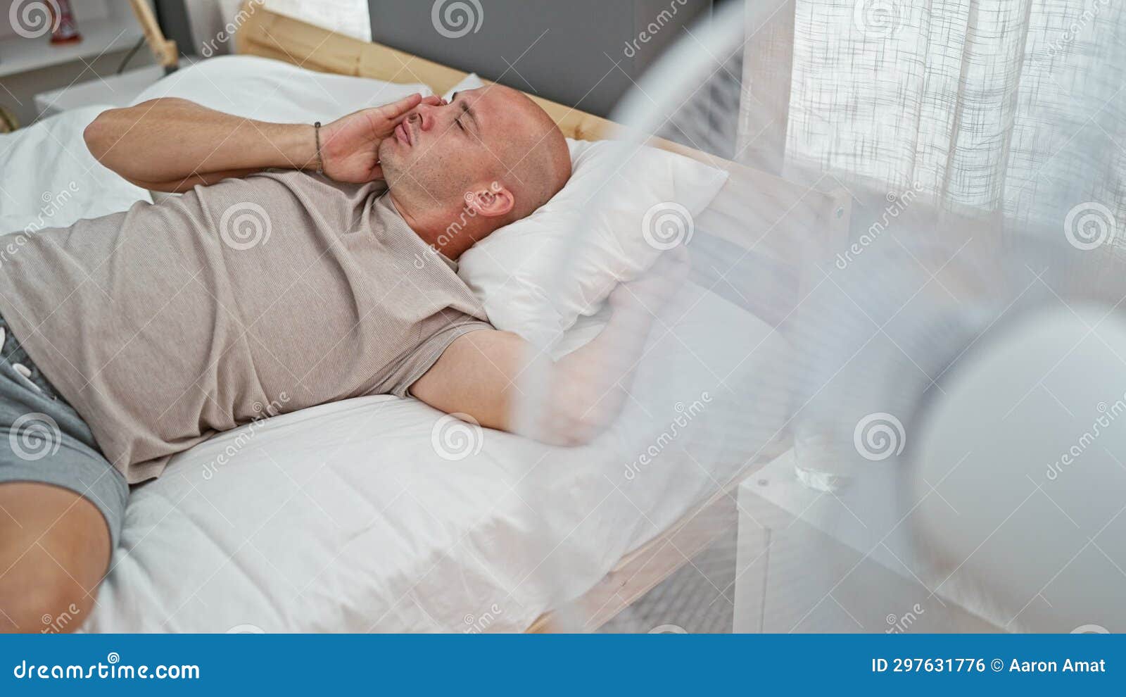Young Hispanic Man Lying on Bed Sweating Using Ventilator at Bedroom ...