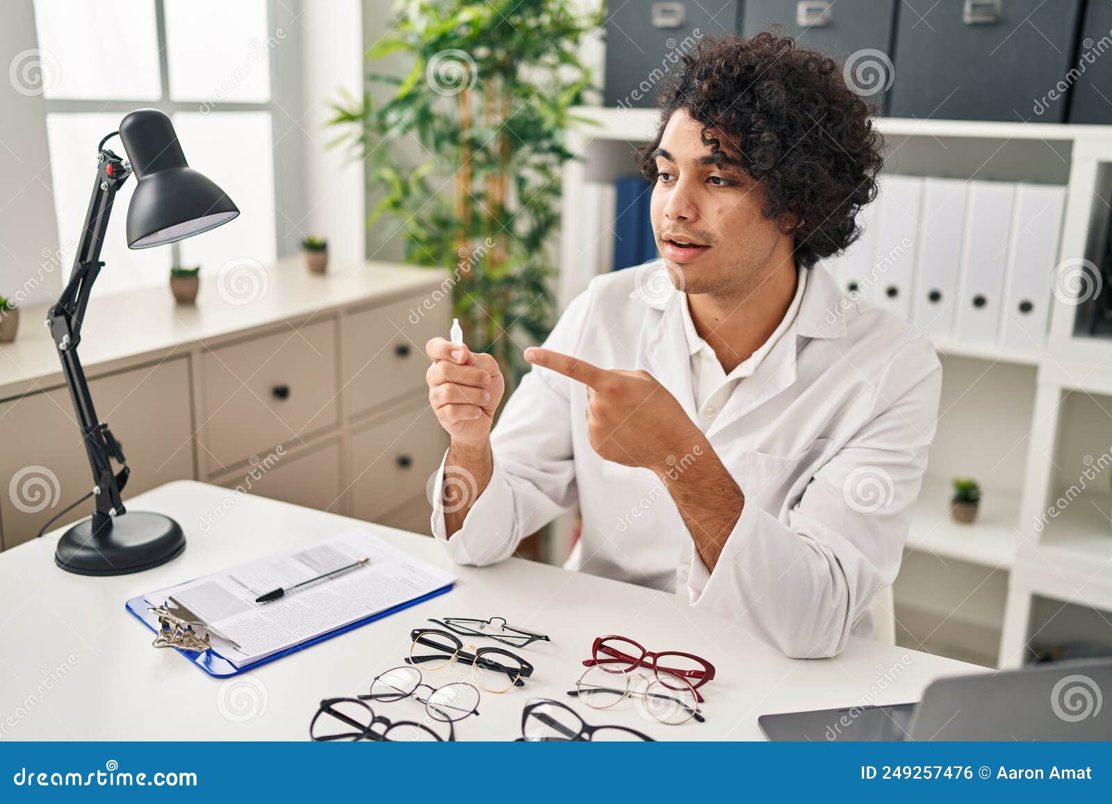 Young Hispanic Man Optician Holding Eye Drop at Clinic Stock Photo ...