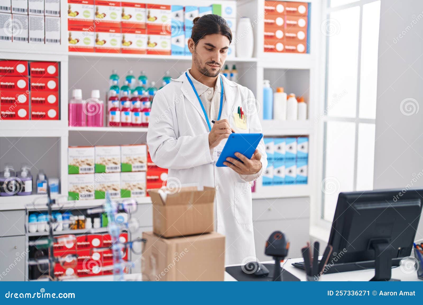 Young Hispanic Man Pharmacist Using Touchpad Working at Pharmacy Stock ...