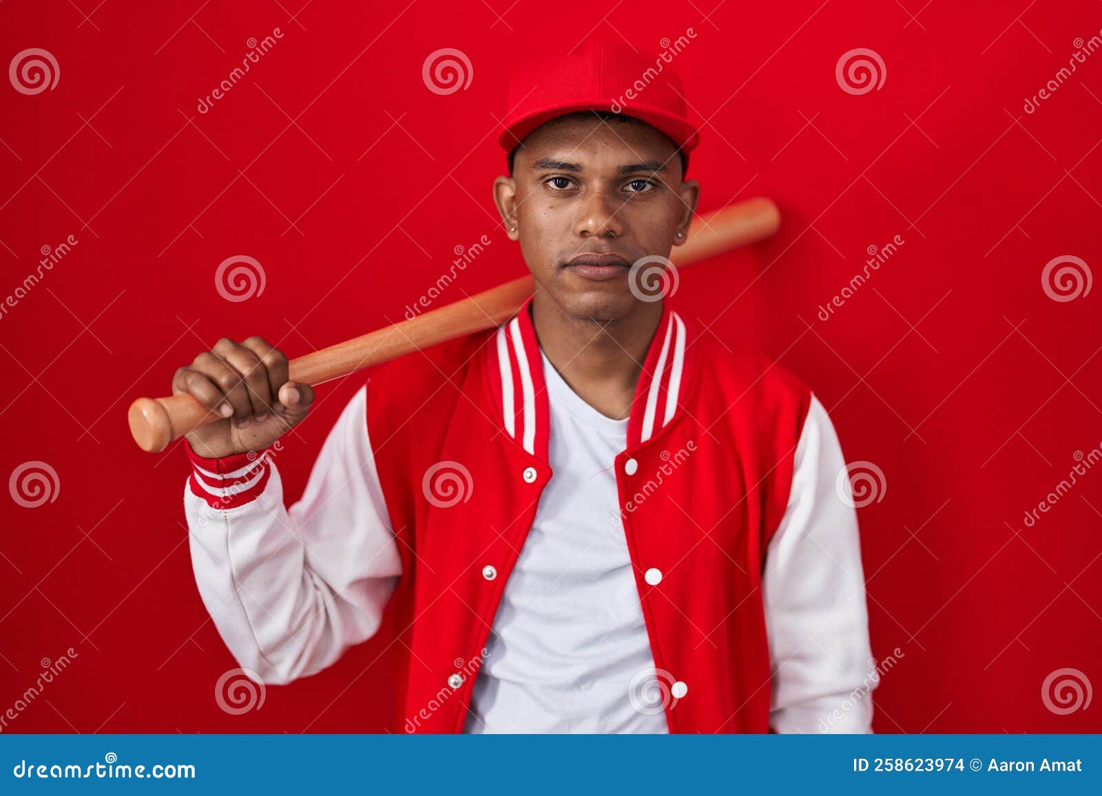 Young Hispanic Man Playing Baseball Holding Bat Relaxed with Serious ...