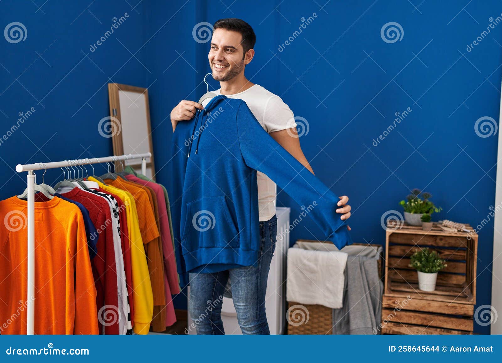 Young Hispanic Man Putting Clothes on Clothes Rack at Laundry Room ...