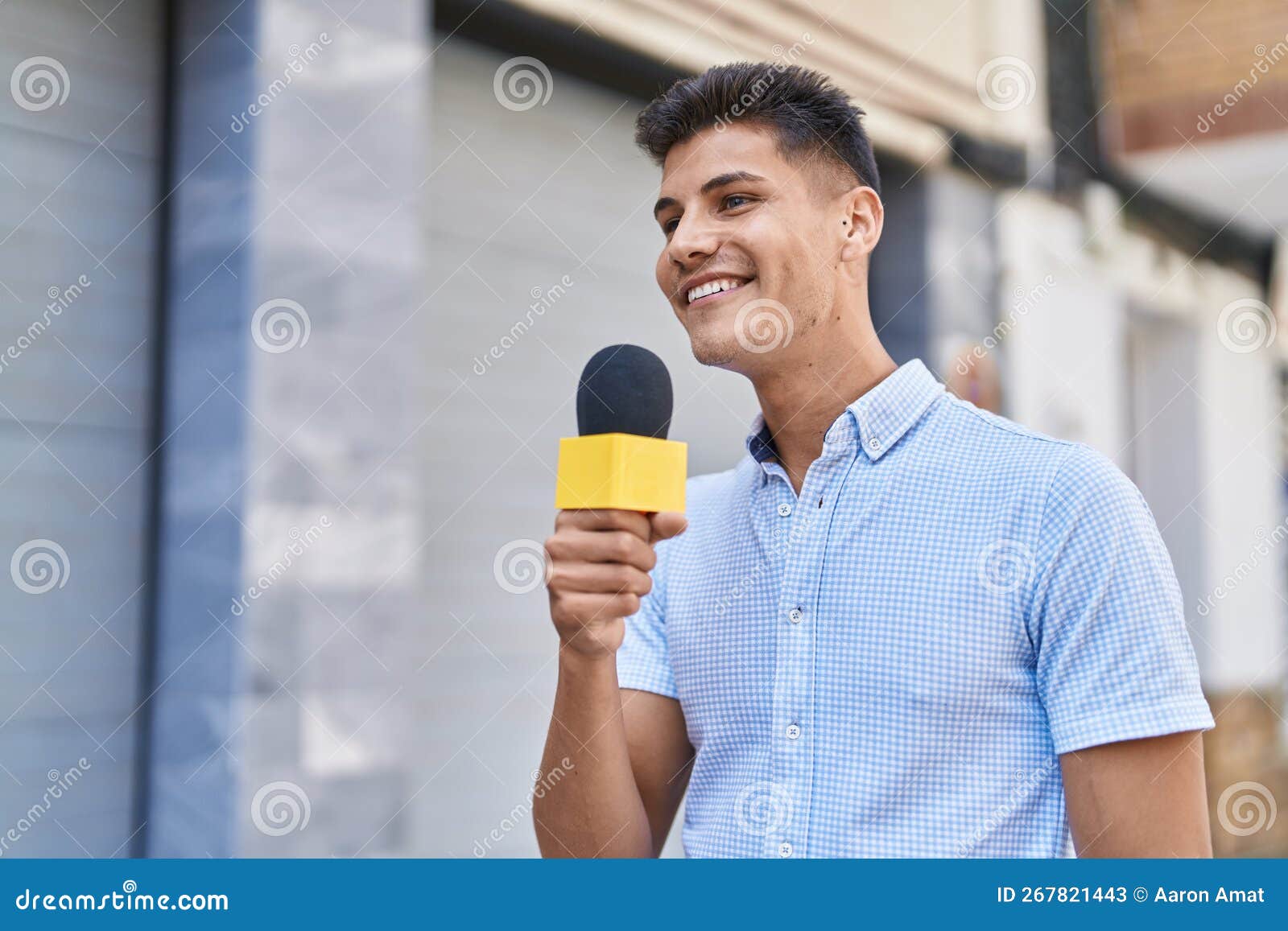 Young Hispanic Man Reporter Working Using Microphone at Street Stock ...