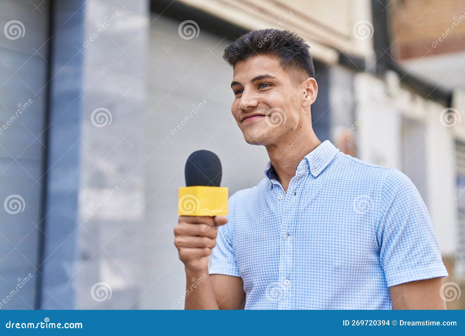 Young Hispanic Man Reporter Working Using Microphone at Street Stock ...