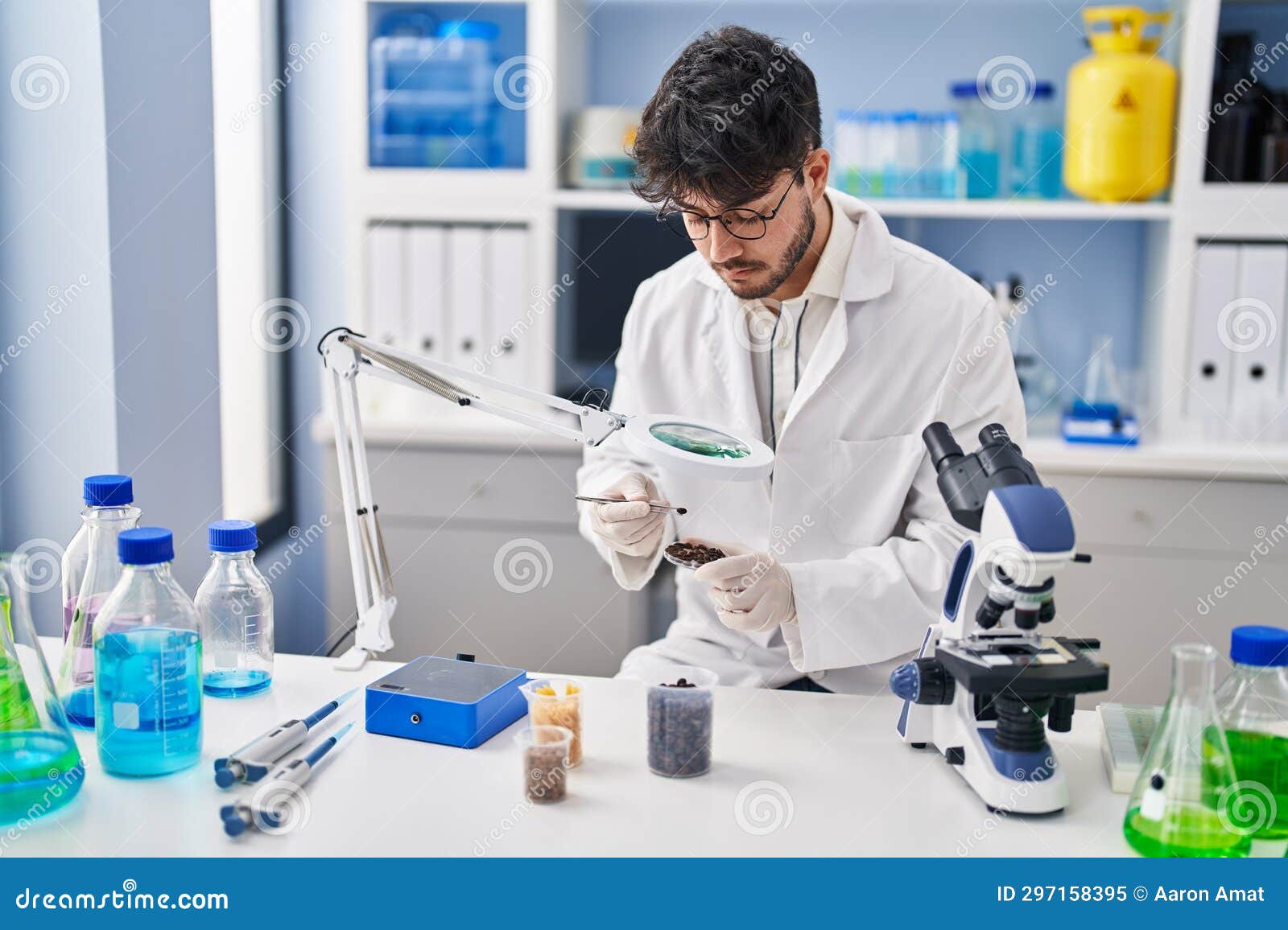 Young Hispanic Man Scientist Looking Sample with Loupe at Laboratory ...