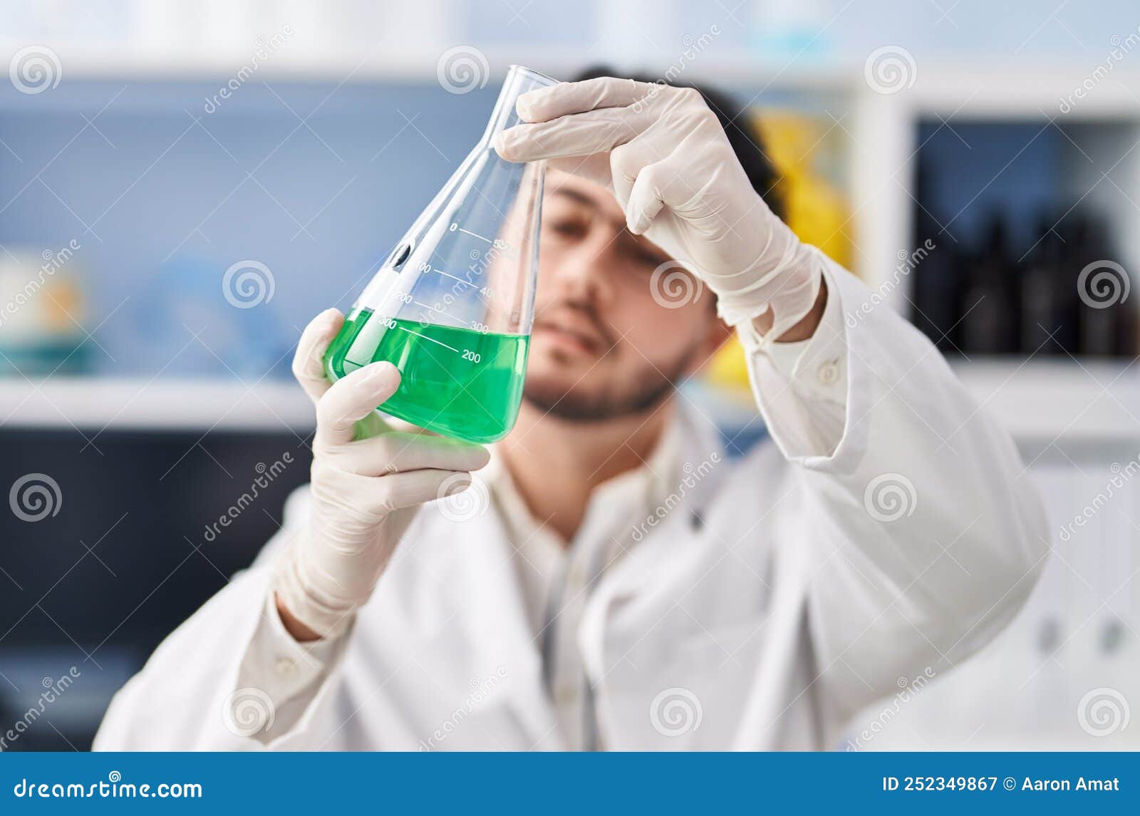 Young Hispanic Man Scientist Measuring Liquid at Laboratory Stock Image ...