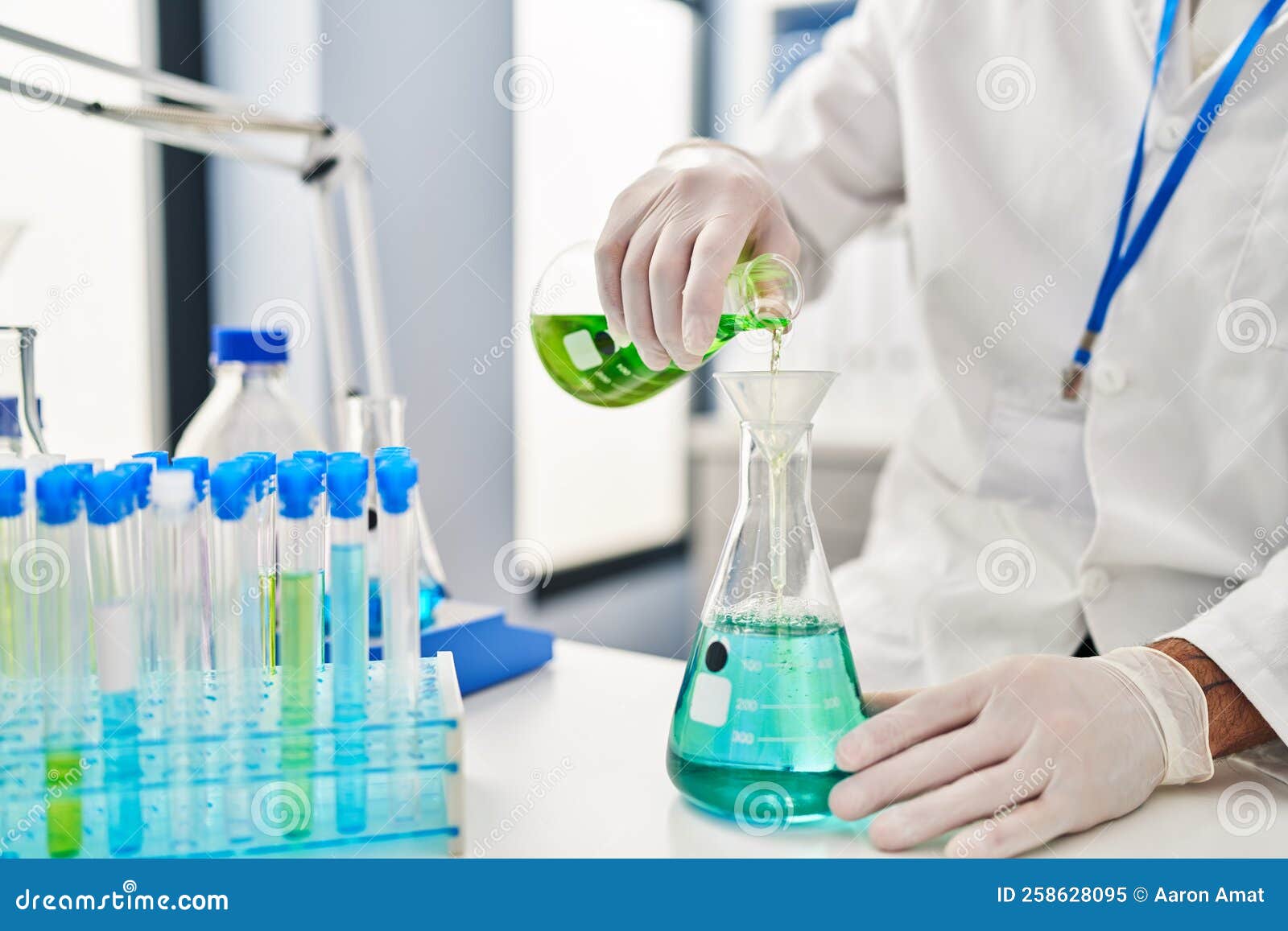 Young Hispanic Man Scientist Measuring Liquid at Laboratory Stock Image ...