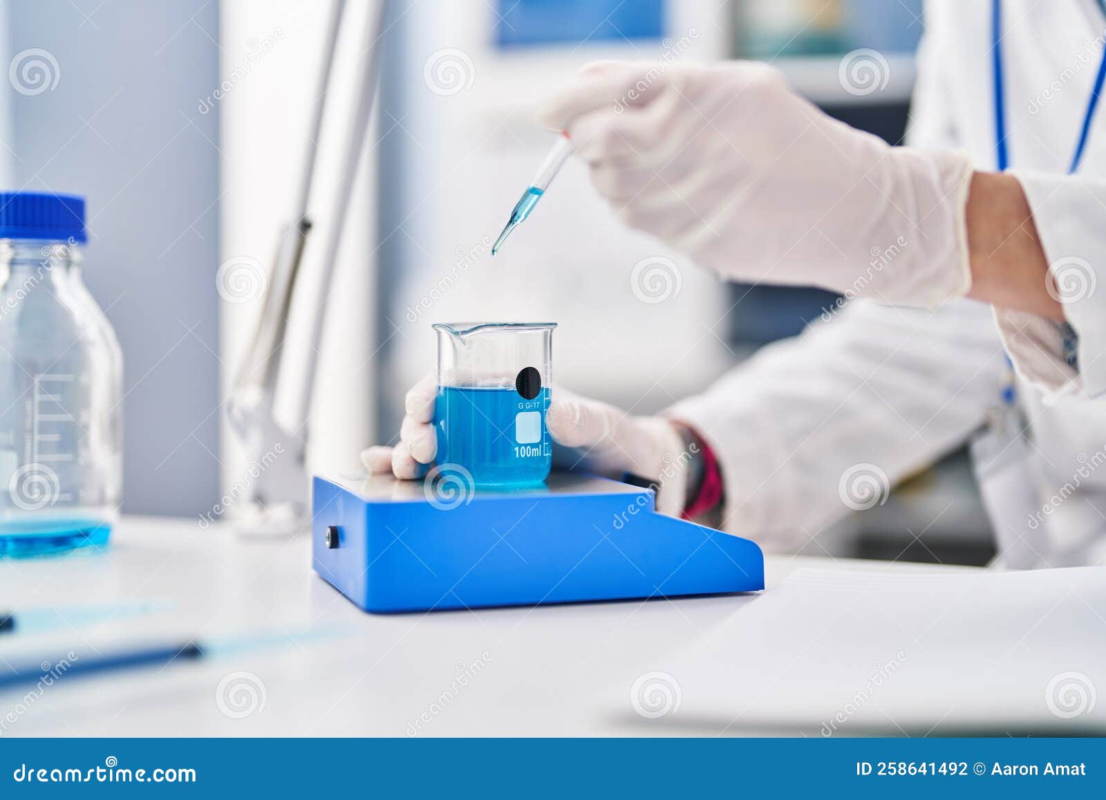 Young Hispanic Man Scientist Measuring Liquid at Laboratory Stock Photo ...