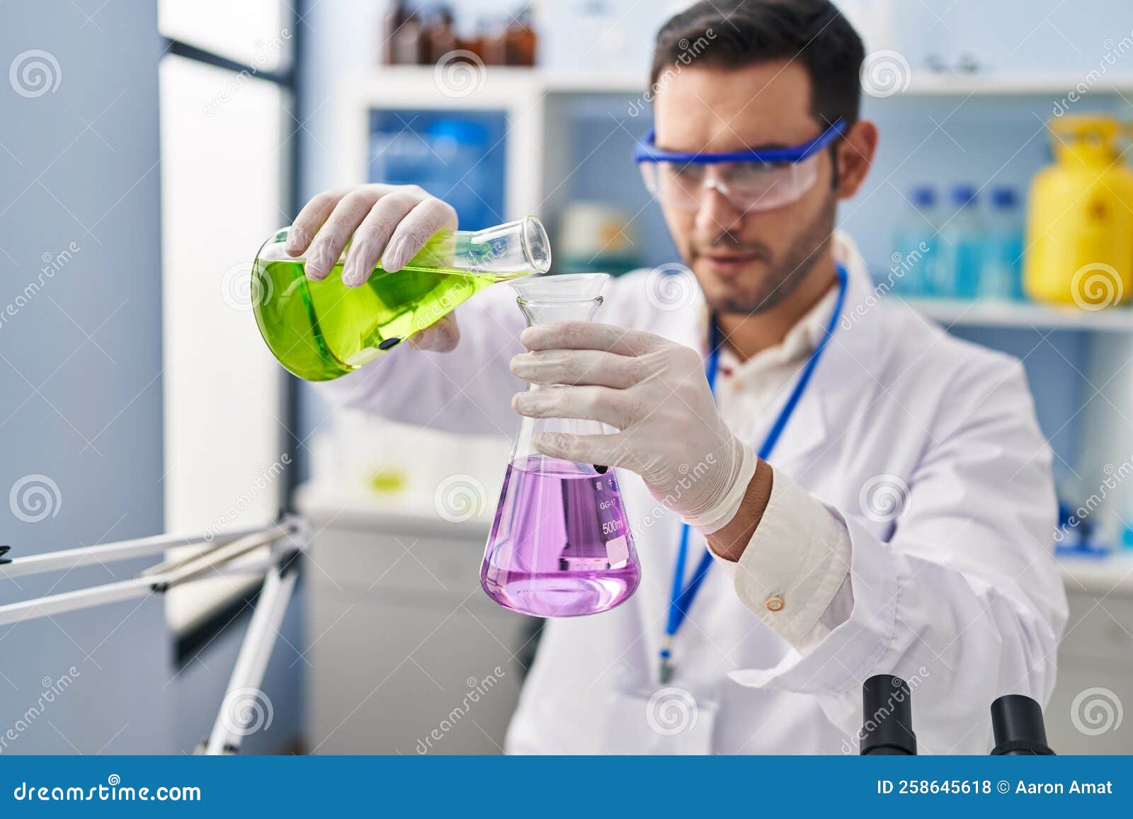 Young Hispanic Man Scientist Measuring Liquid at Laboratory Stock Photo ...