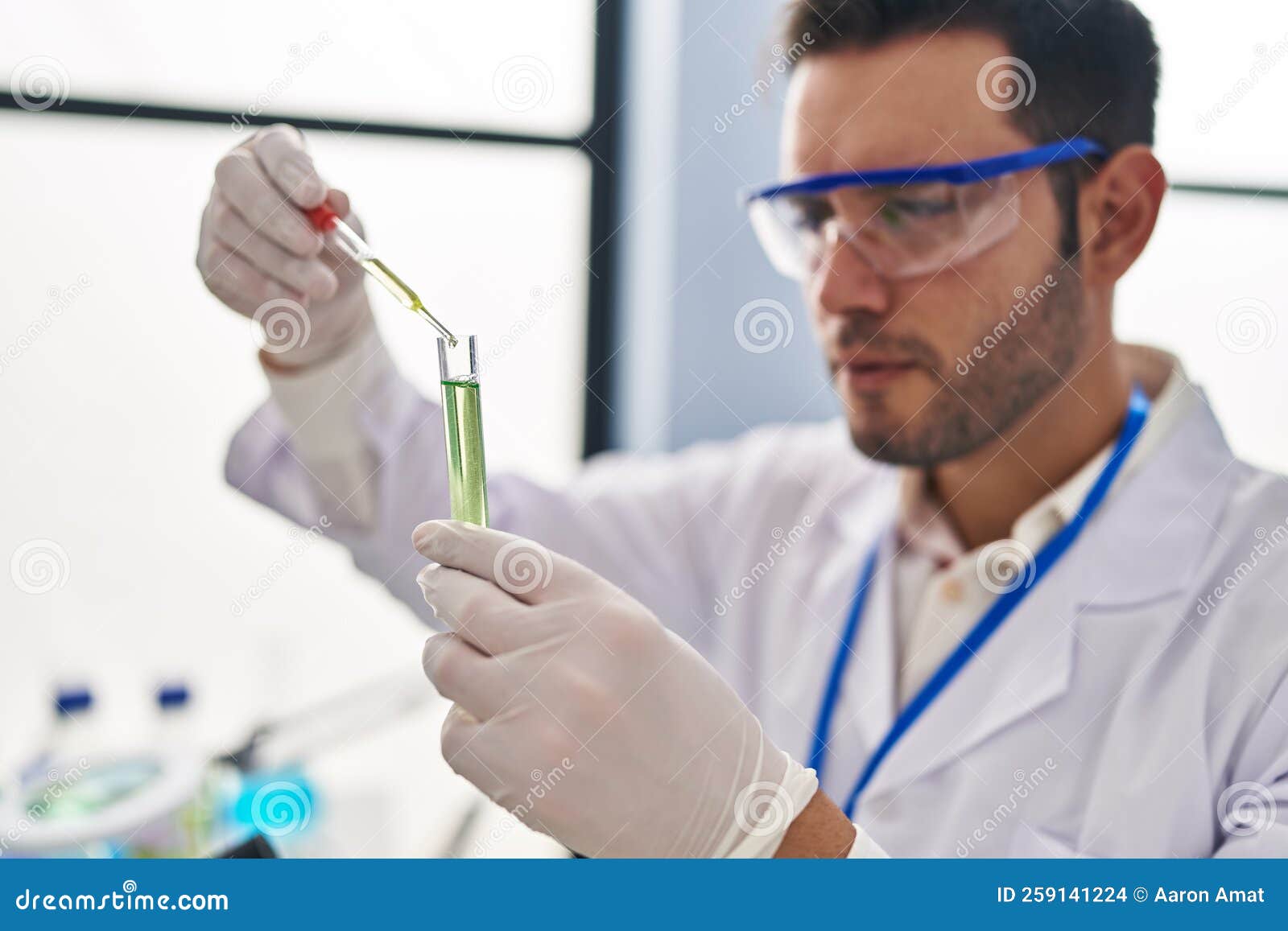Young Hispanic Man Scientist Measuring Liquid at Laboratory Stock Photo ...