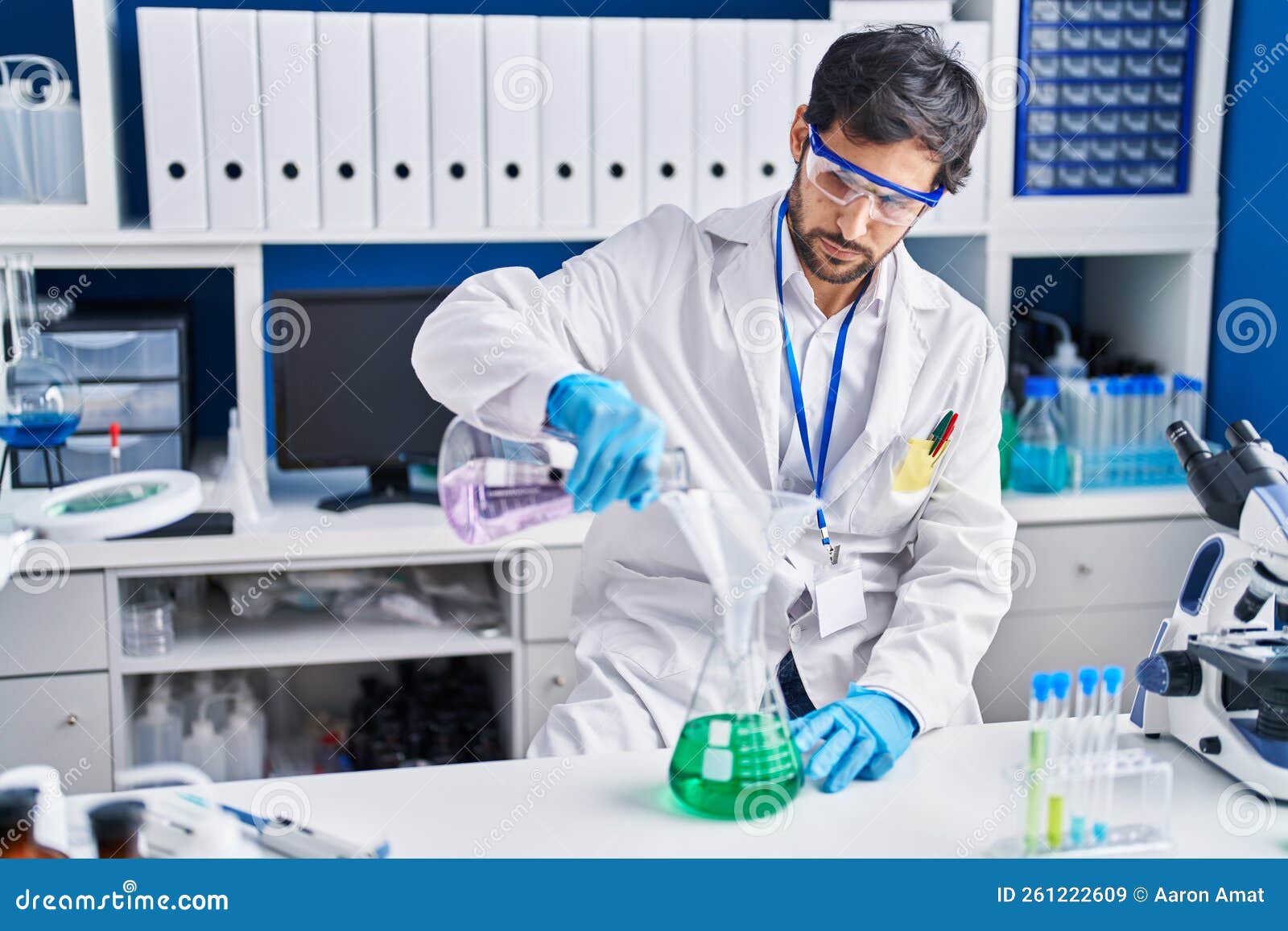 Young Hispanic Man Scientist Measuring Liquid at Laboratory Stock Image ...