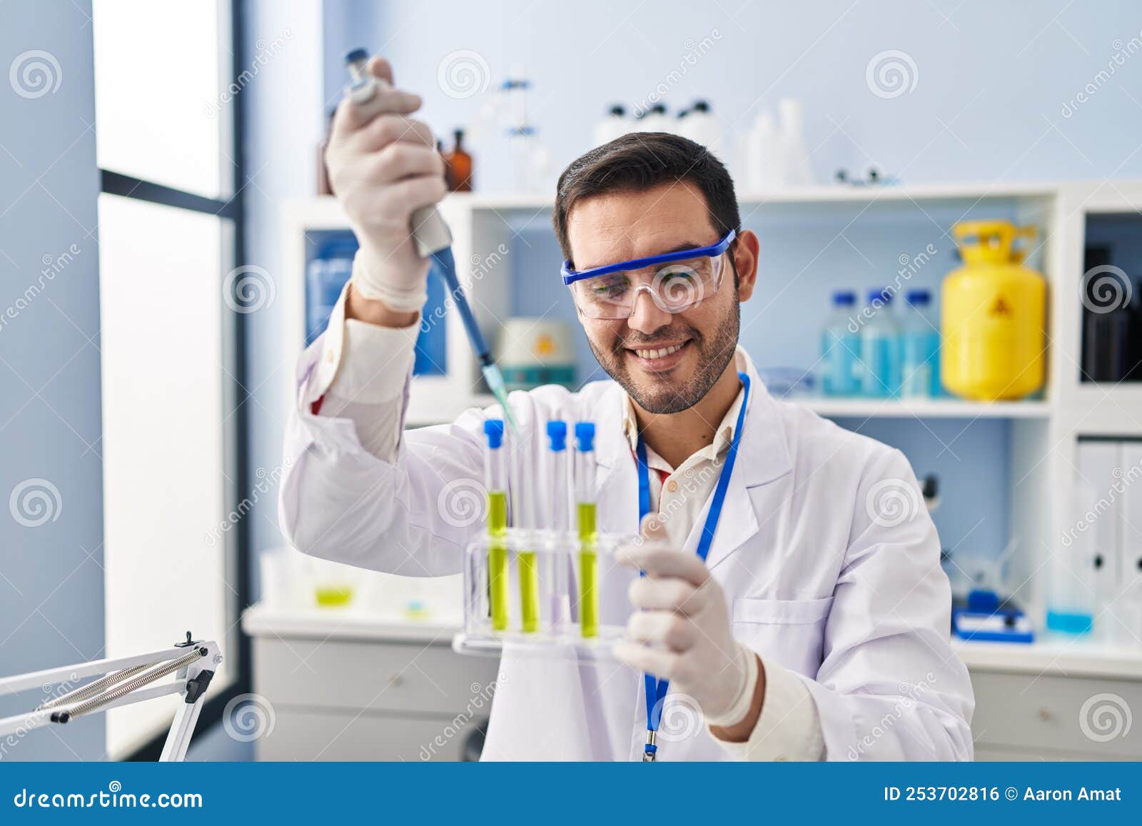 Young Hispanic Man Scientist Measuring Liquid Using Pipette at ...