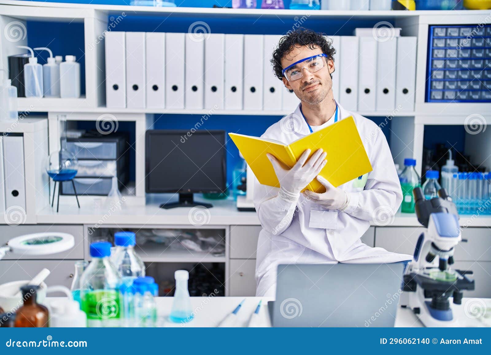 Young Hispanic Man Scientist Reading Book at Laboratory Stock Photo ...