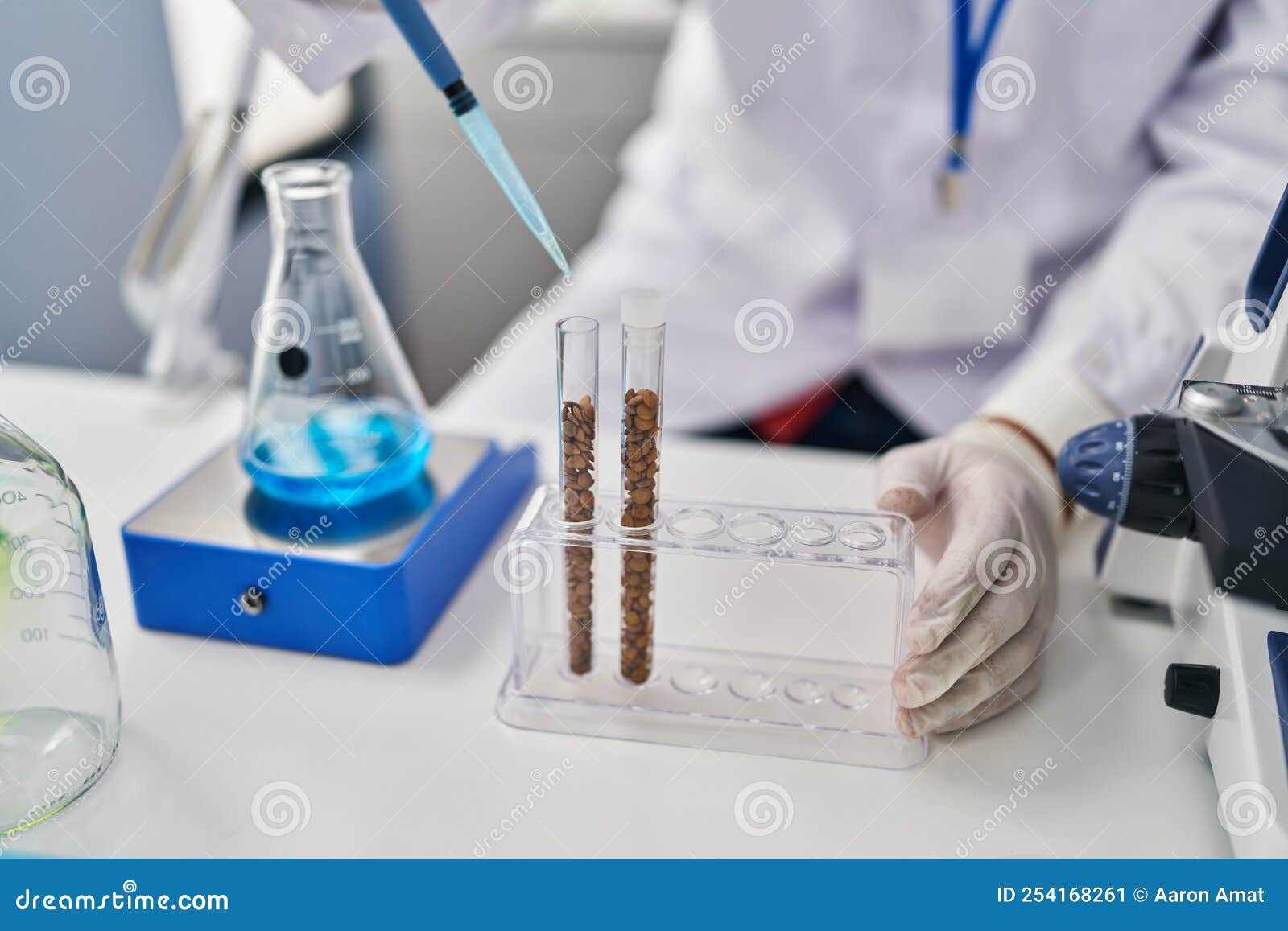 Young Hispanic Man Scientist Using Pipette Pouring Liquid at Laboratory ...