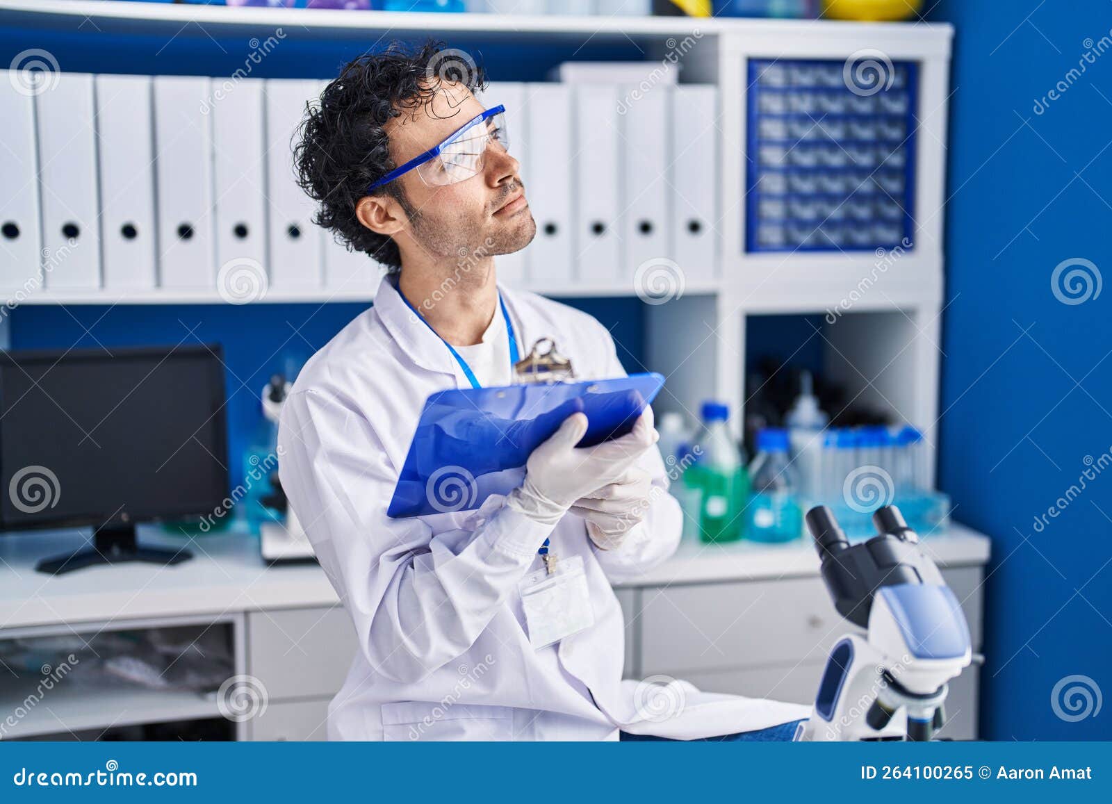 Young Hispanic Man Scientist Writing on Document at Laboratory Stock ...