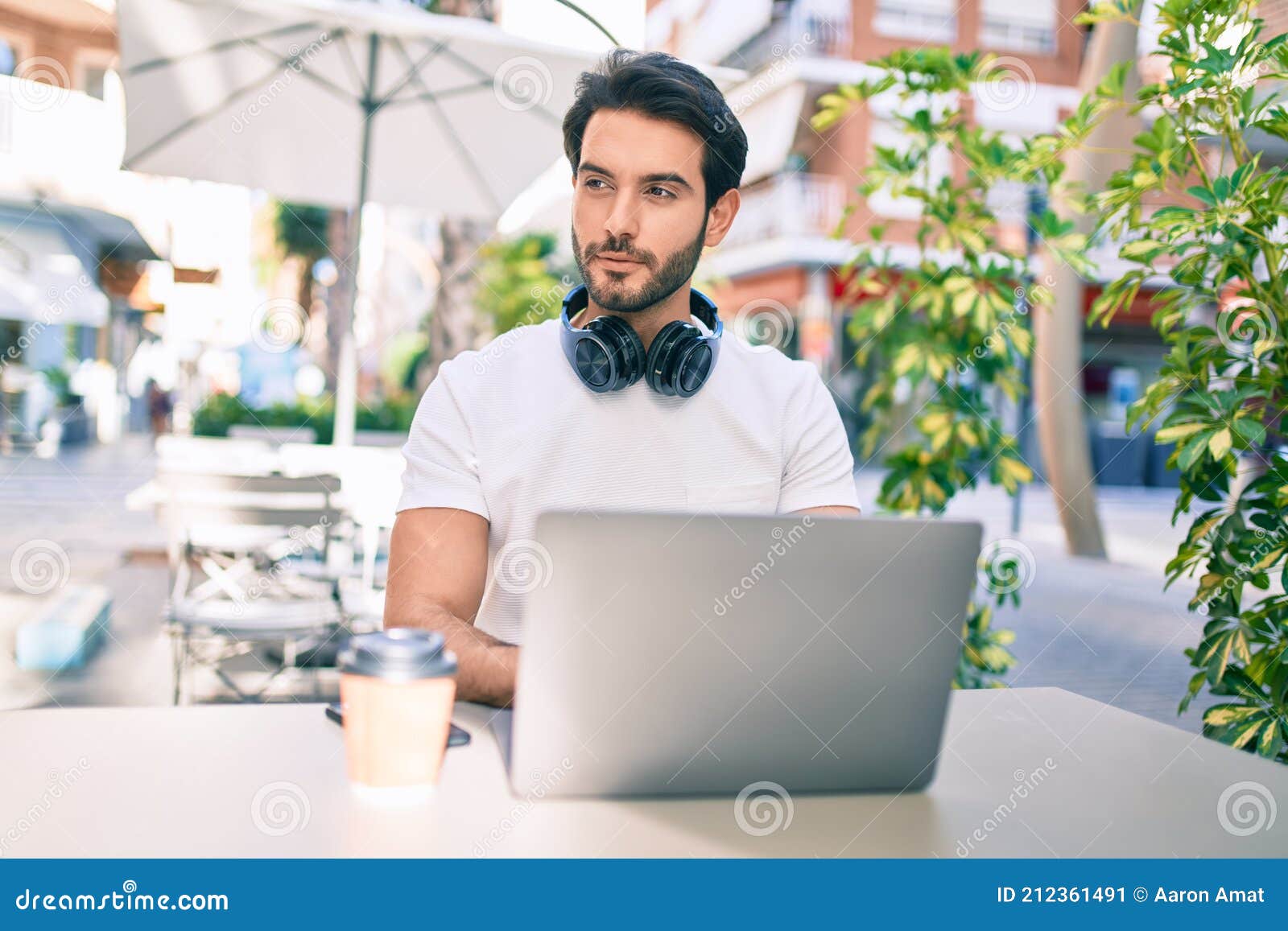 Young Hispanic Man with Serious Expression Working Using Laptop at ...