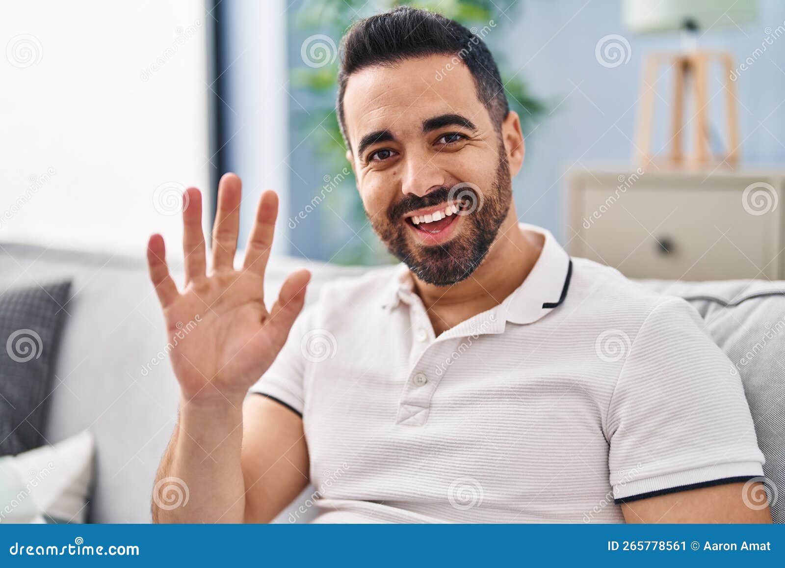Young Hispanic Man Sitting On Sofa Talking At Home Stock Image Image