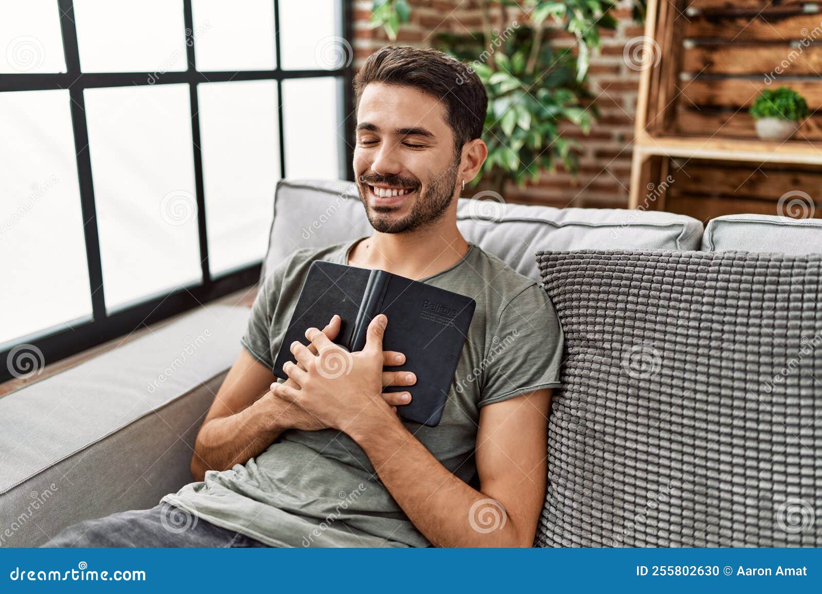 Young Hispanic Man Smiling Confident Hugging Bible at Home Stock Photo ... Young Hispanic Man Smiling Confident Hugging Bible at Home Stock Photo ...