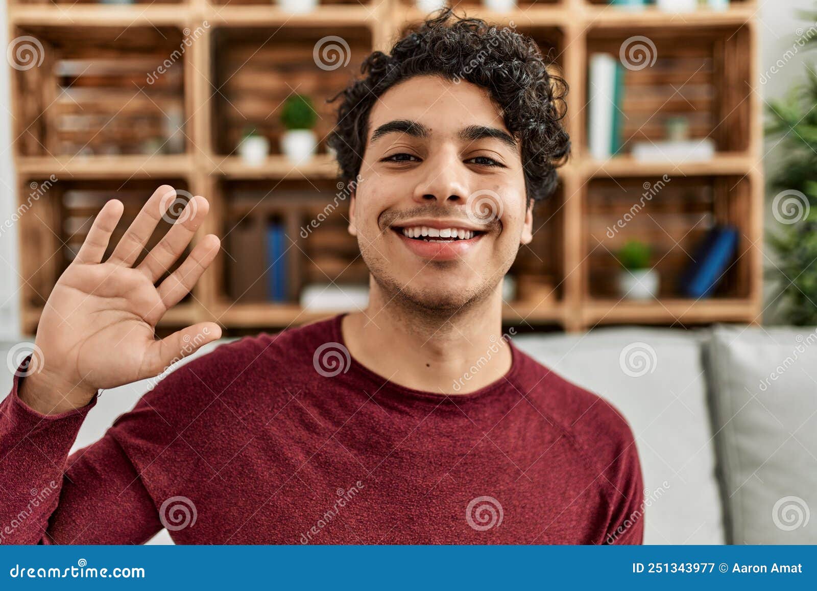 Young Hispanic Man Smiling Happy Saying Hello with Hand at Home Stock ...
